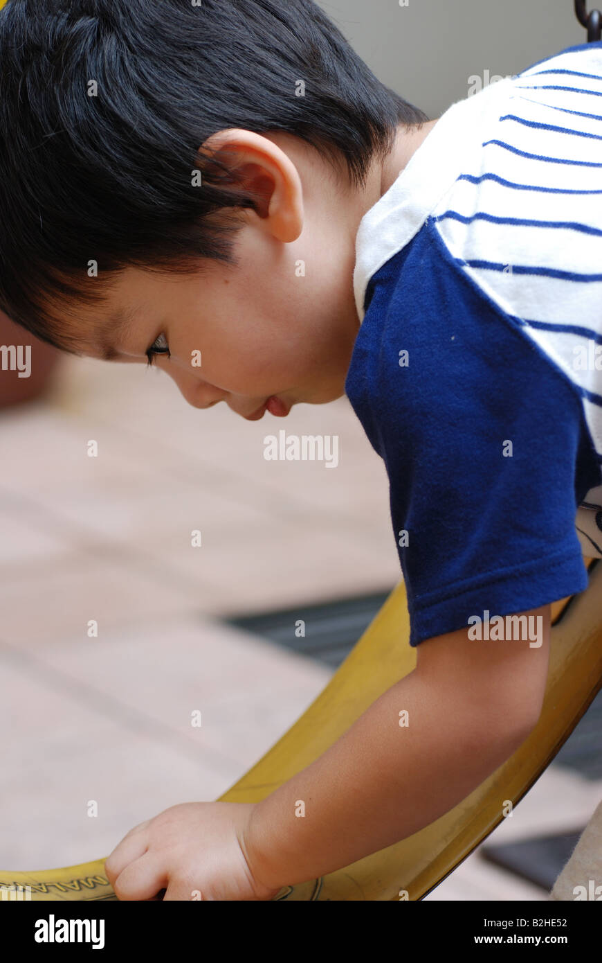 Curious expression of toddler crouching Stock Photo - Alamy