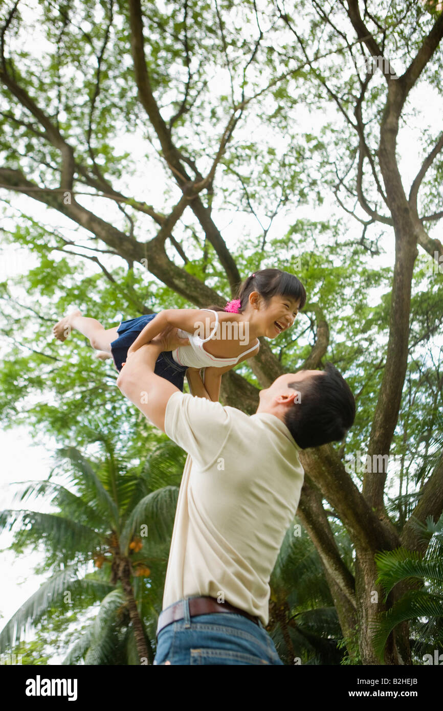 Mid adult man tossing his daughter in air, Singapore Stock Photo - Alamy