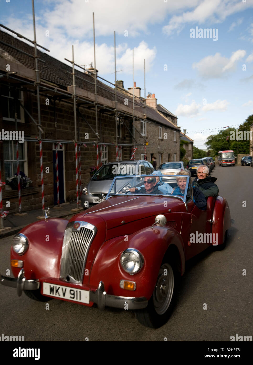 People in classic red car Winster village Derbyshire Peak District ...