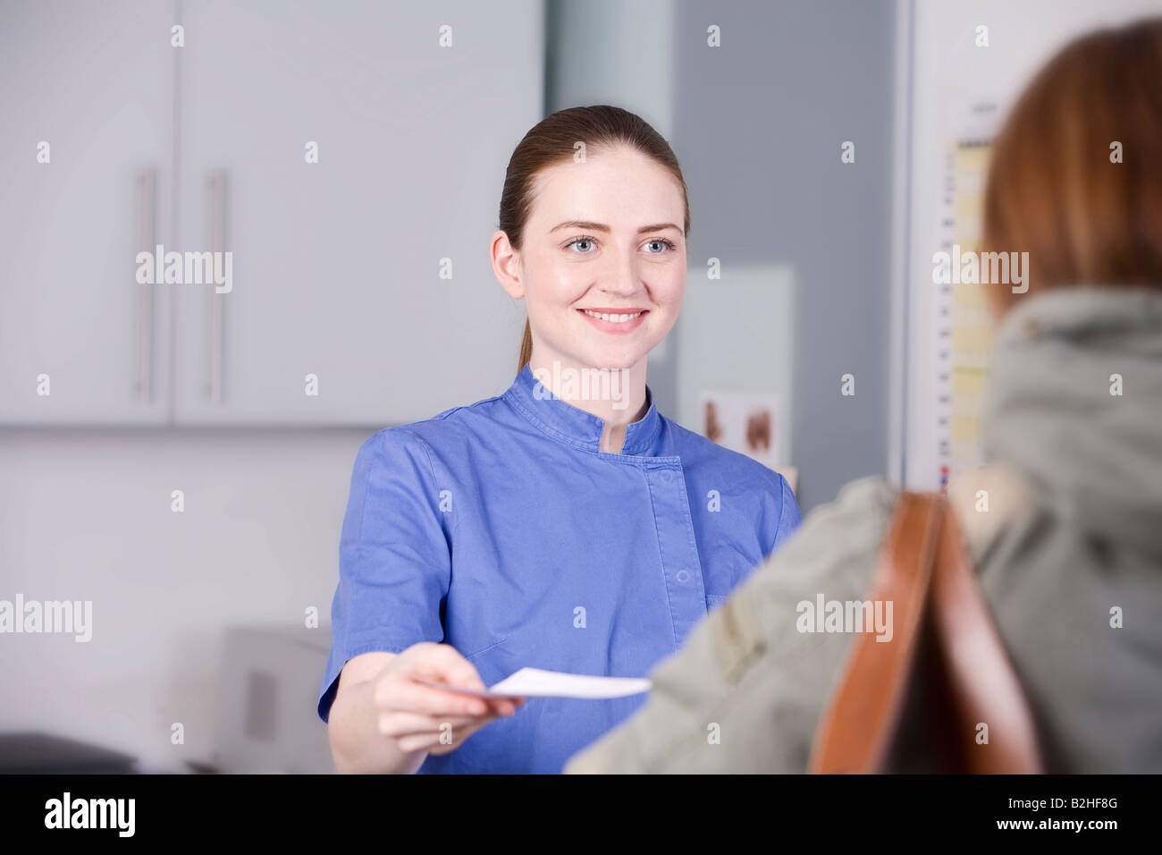 medical assistent giving prescription to patient Stock Photo - Alamy