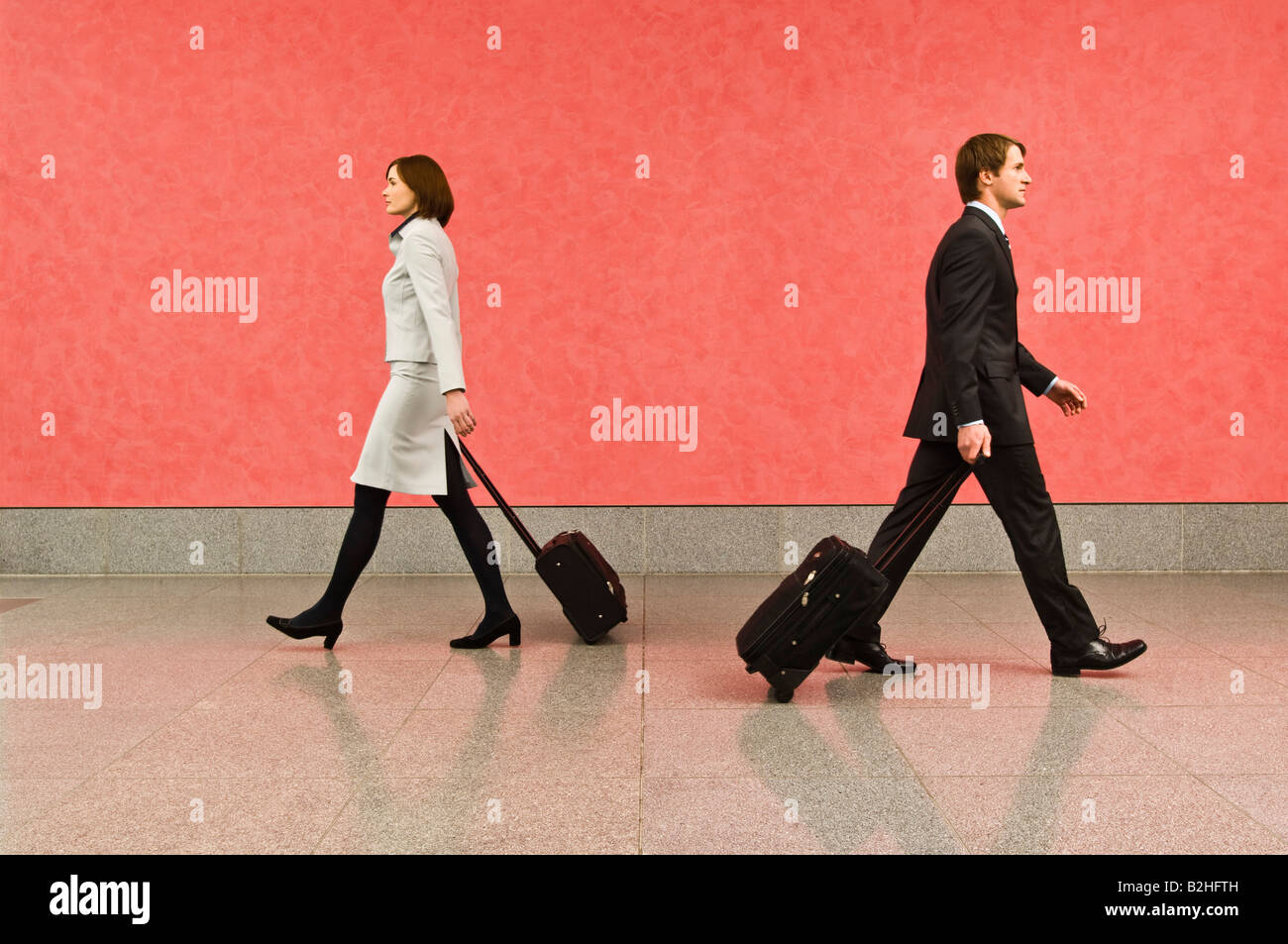 two business travellers in corridor pulling carry-on suitcases Stock ...
