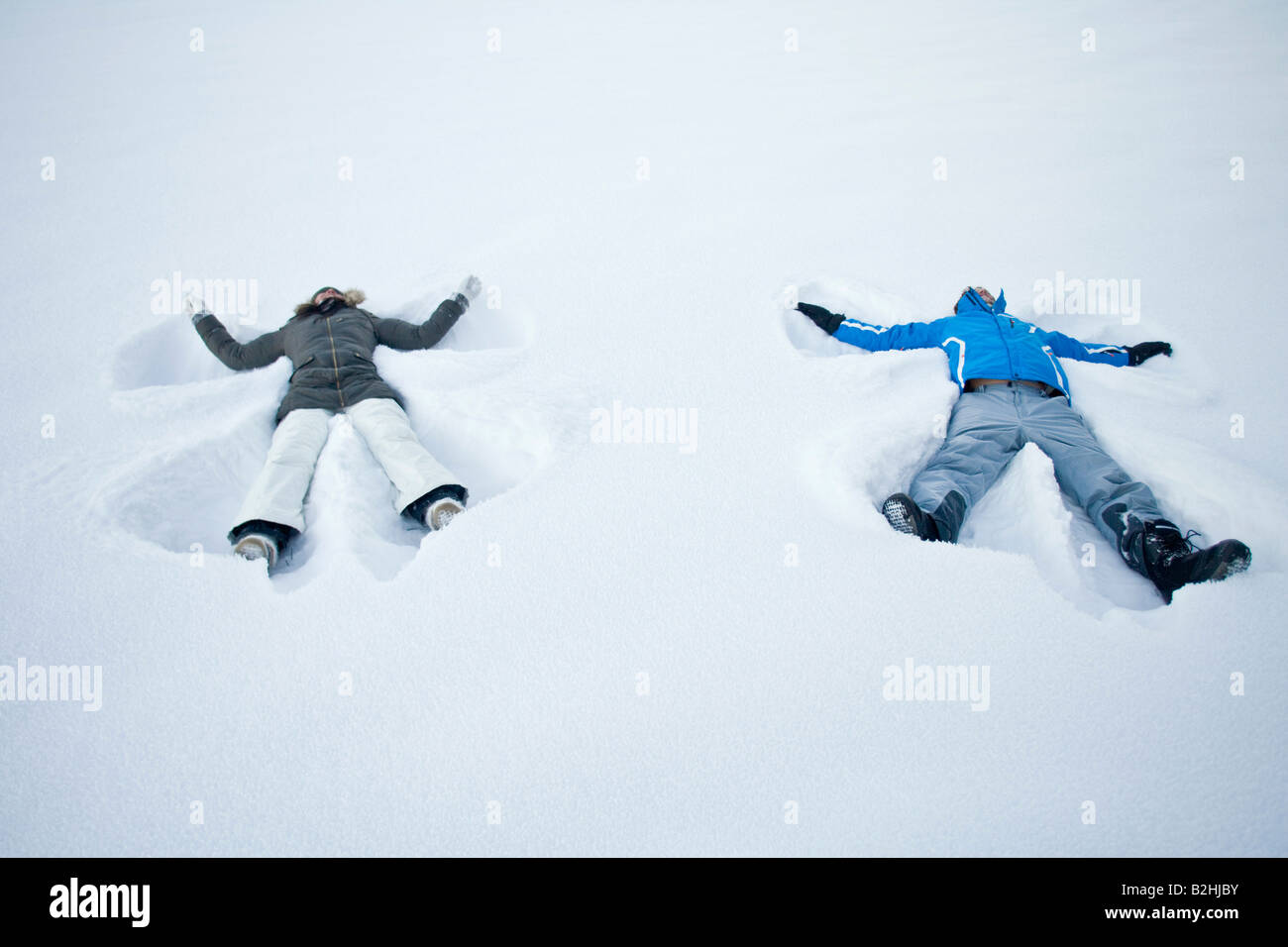 young couple lying in snow doing snow angels Stock Photo - Alamy