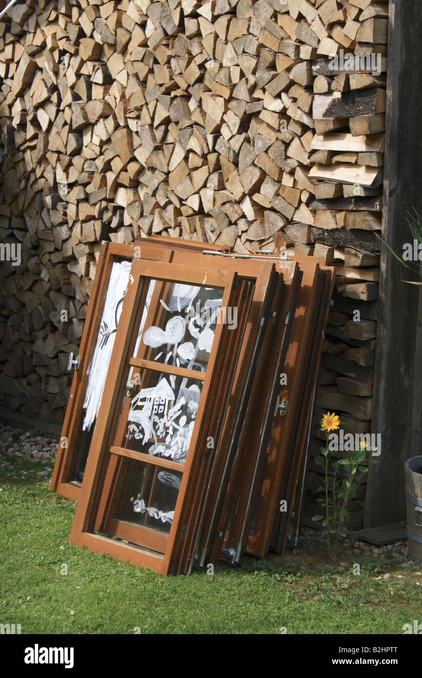 removed vintage windows leaning against pile of firewood at barn. Photo ...