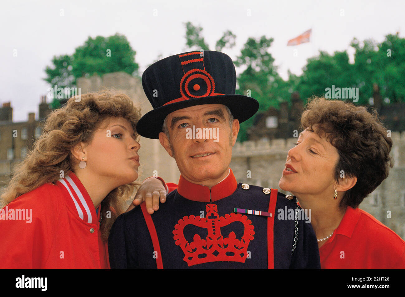 England. London. Beefeater man with tourists at the Tower of London ...