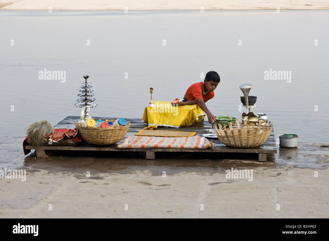 A young Hindu boy preparing for a religious ceremony on the banks of ...