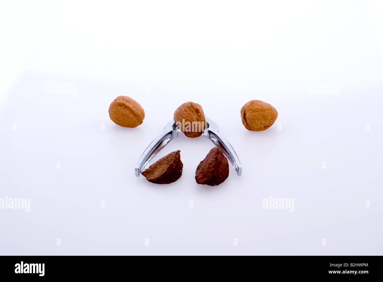 5 nuts surrounding a nutcracker Stock Photo - Alamy