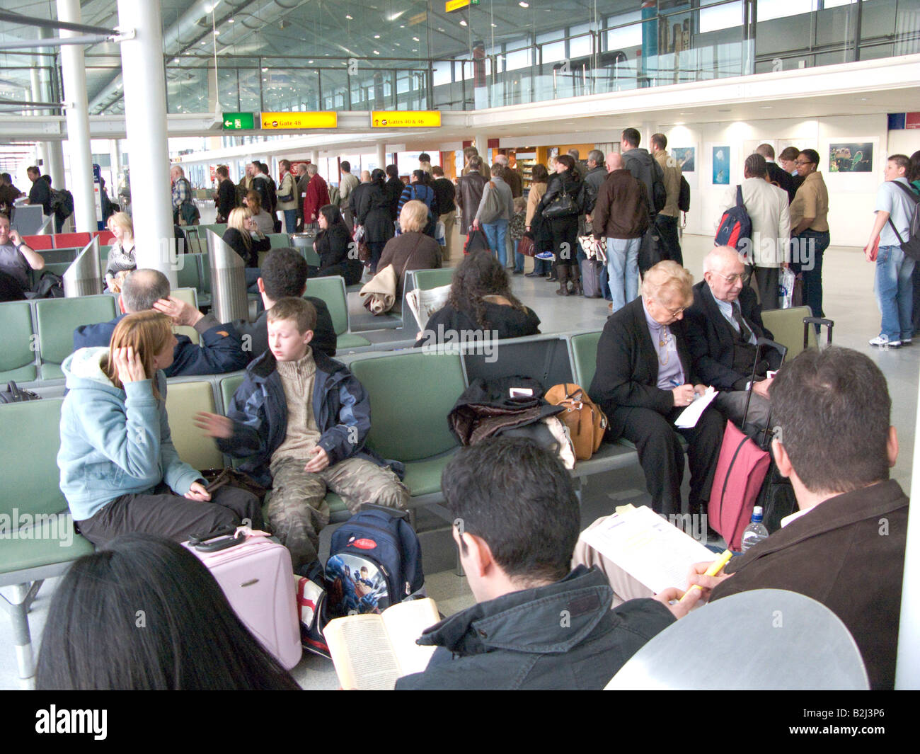 Passengers queue for their plane at Terminal 1 Heathrow Airport Stock ...