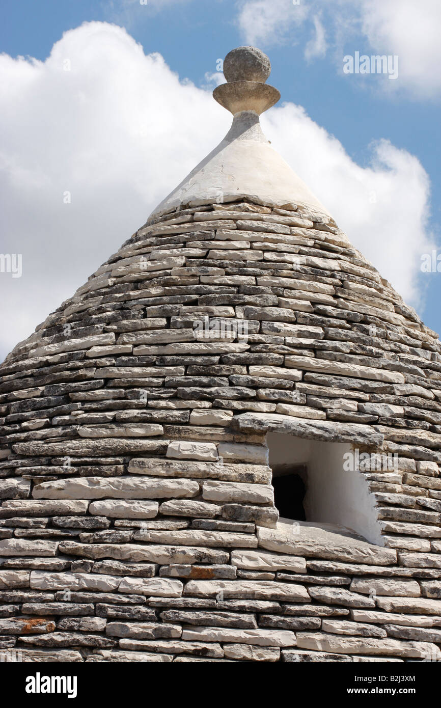 Traditional Trulli house roof , a cross and a window in the roof ...