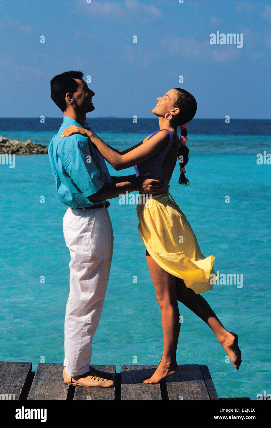 Maldives. Side view of romantic young couple standing on oceanfront ...