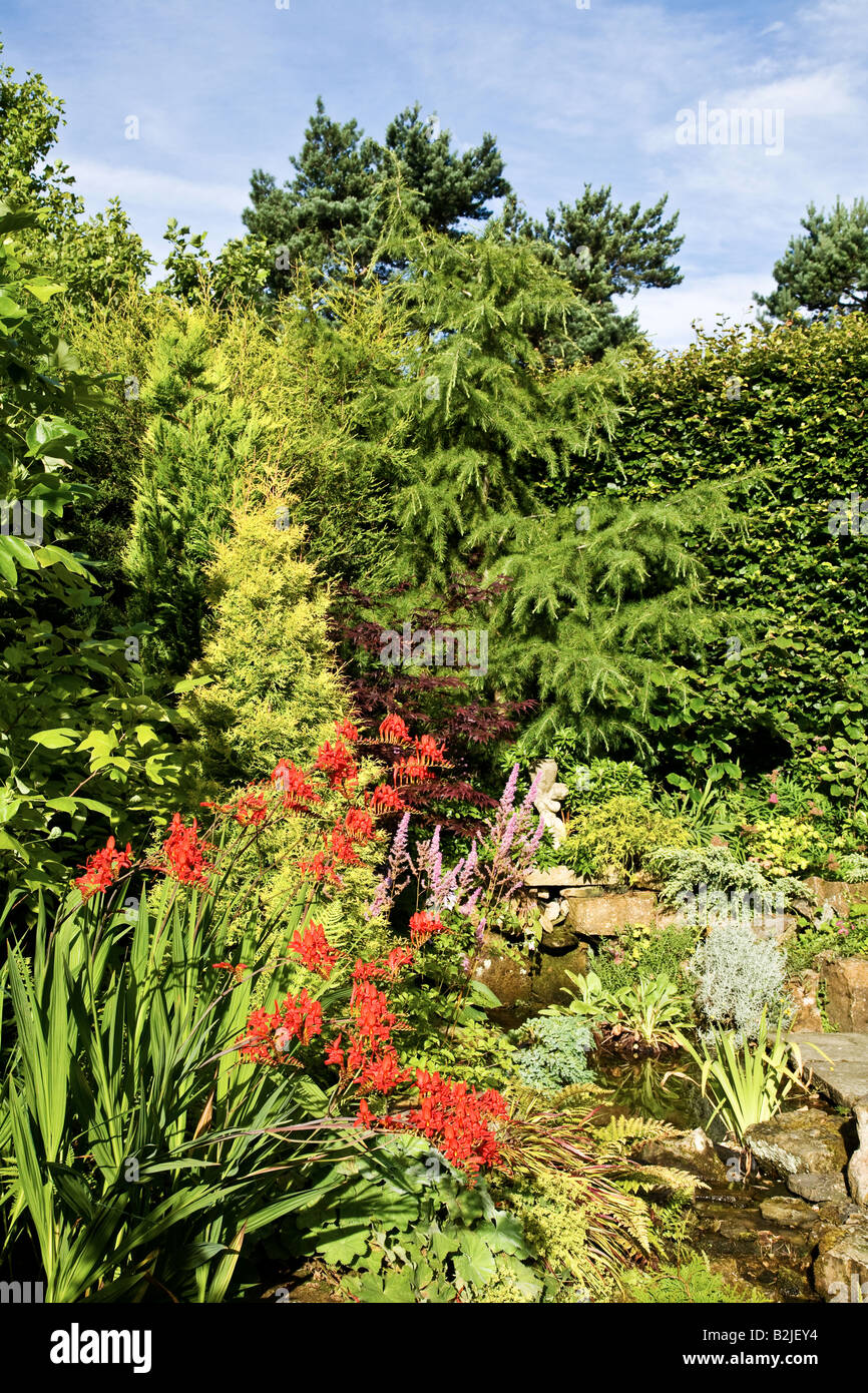 RED CROCOSMIA AND STREAM-SIDE PLANTING IN AN ENGLISH GARDEN Stock Photo ...
