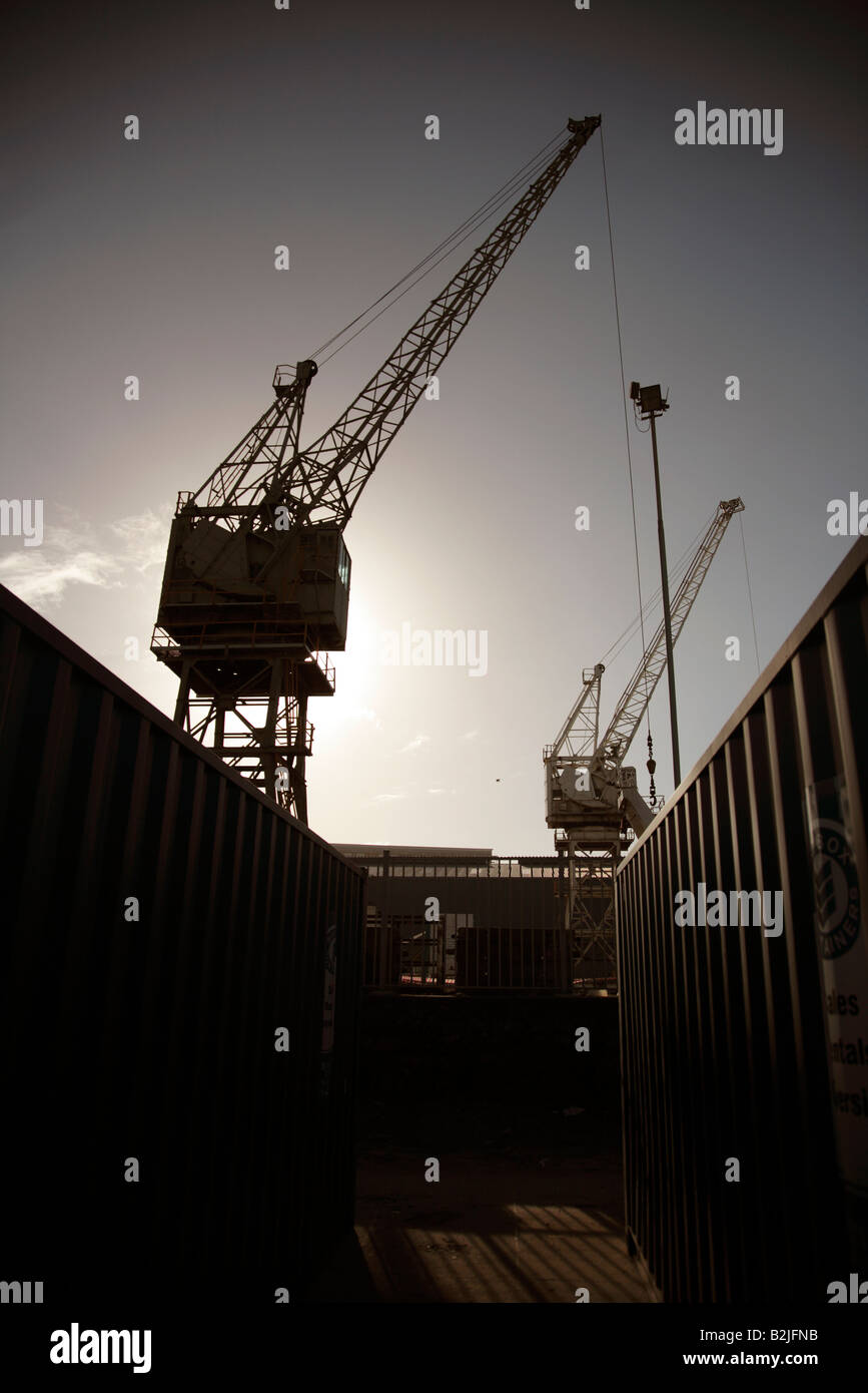 Derricks in working harbour with shipping containers Stock Photo - Alamy