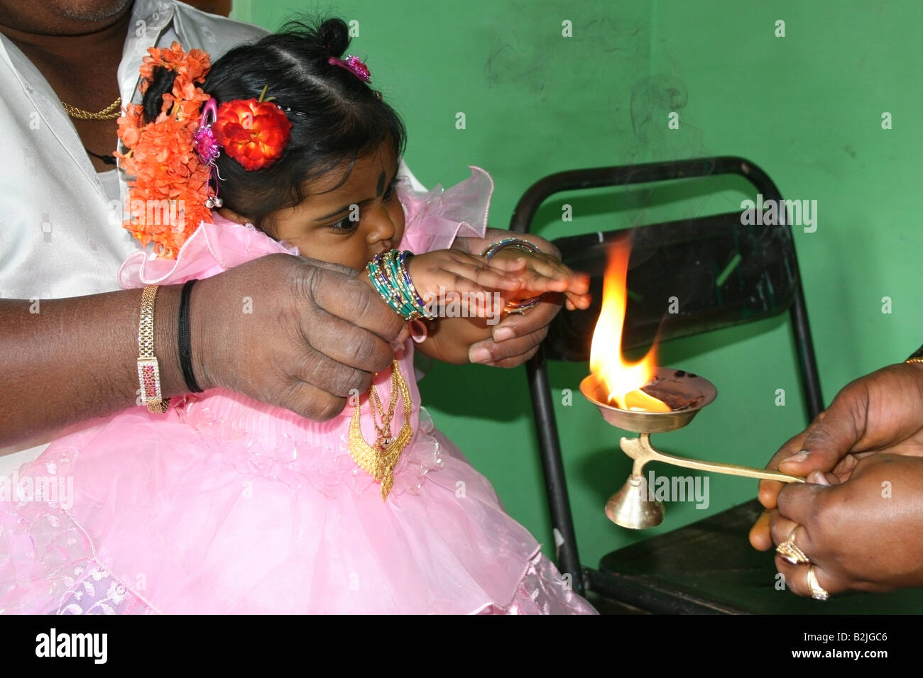 Young Hindu girl performing arti fire pooja during her Namakaran naming ...