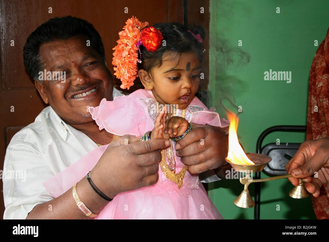 Young Hindu girl performing arti fire pooja during her Namakaran naming ...