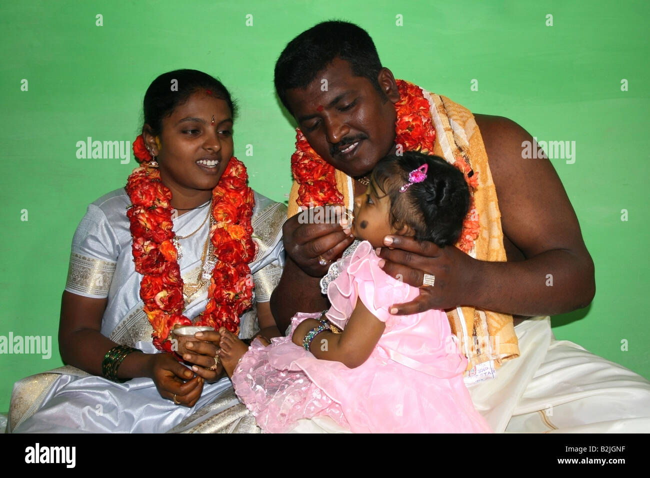 Parents carrying out Namakaran naming ceremony ritual father whispers ...