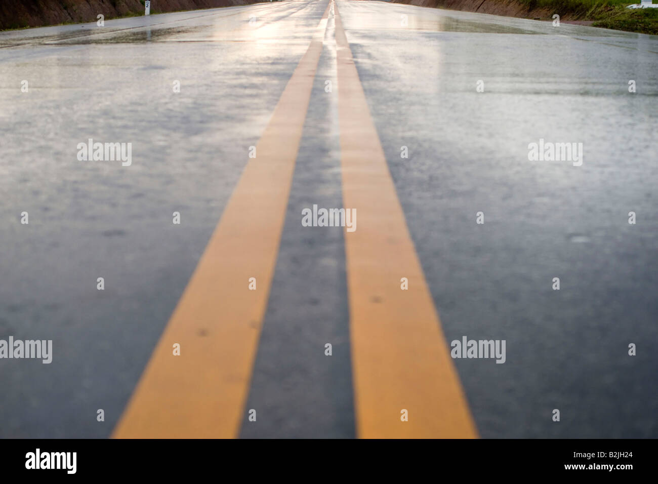 Evening light on a wet road with no passing lines Stock Photo - Alamy