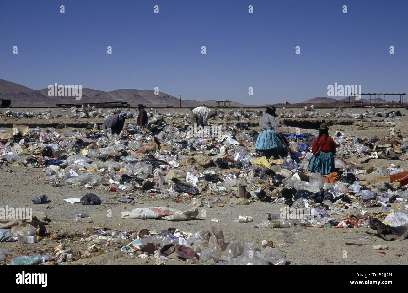 Rubbish dump Five people picking through garbage looking for food ...