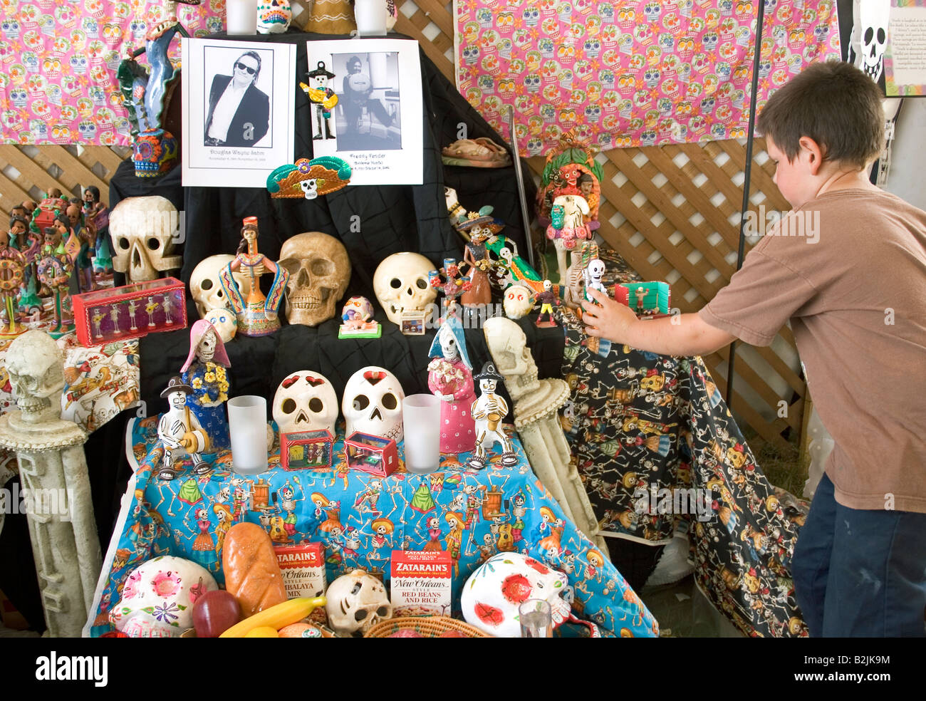 Young boy places a symbolic skeleton figure on Day of the Dead altar at ...