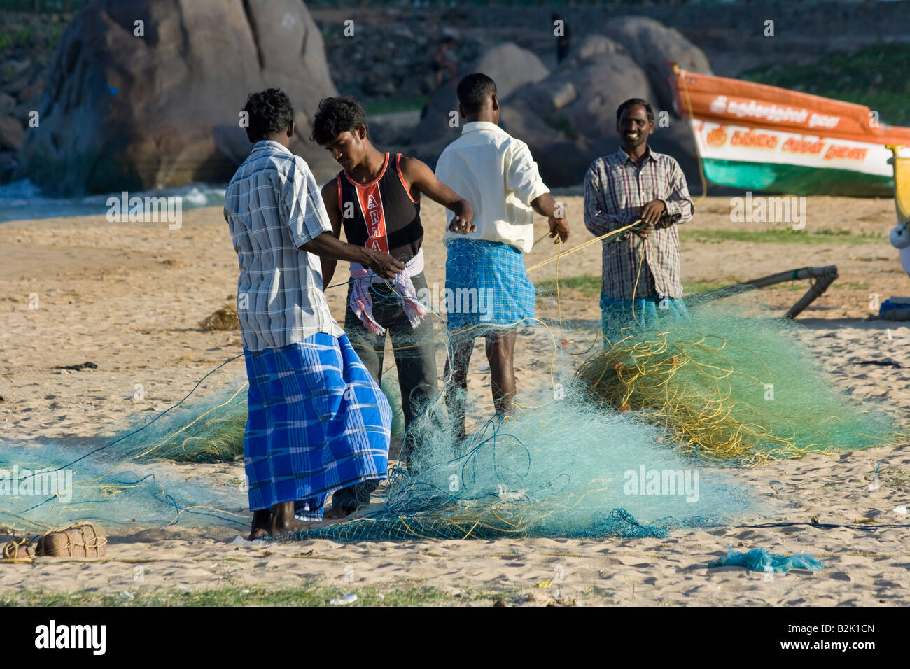Fishermen mending nets on beach hi-res stock photography and images - Alamy