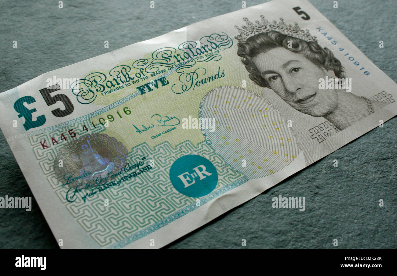 A £5 (five pound note ) on a green slate background Stock Photo - Alamy