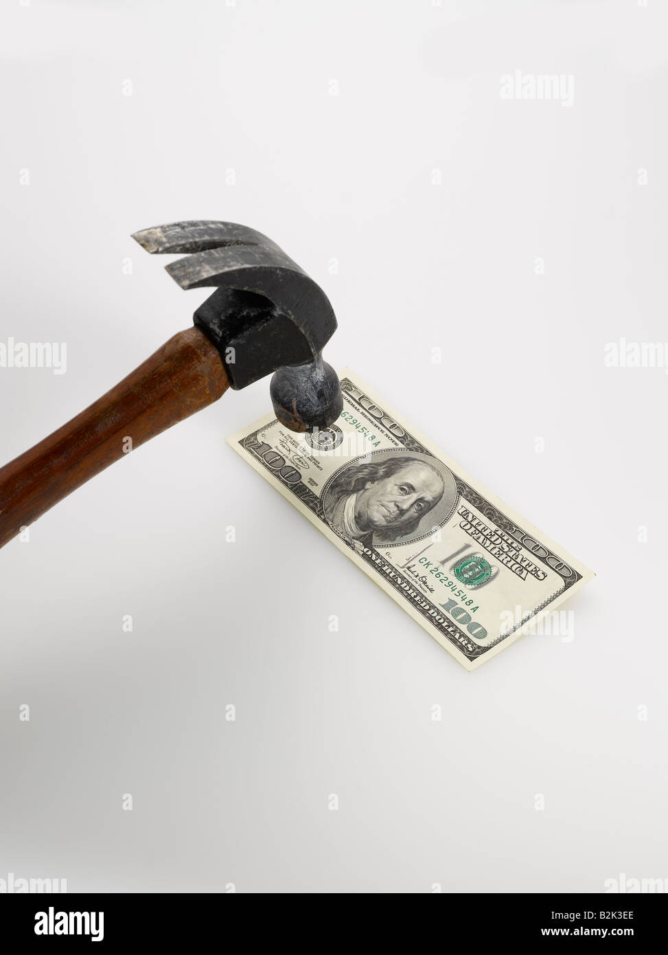 hammer pounding American dollar bills on white background Stock Photo ...