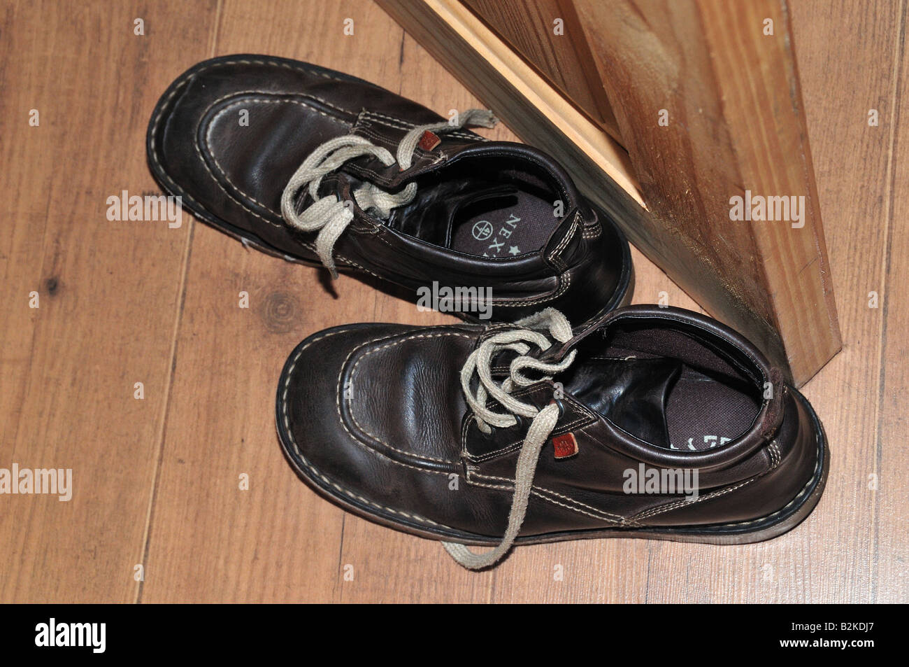 Pair of boots propping a door open Stock Photo - Alamy