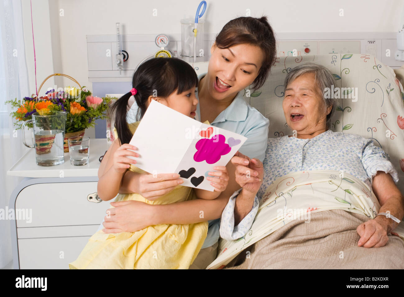 Female patient and her family looking at a Get Well card Stock Photo ...