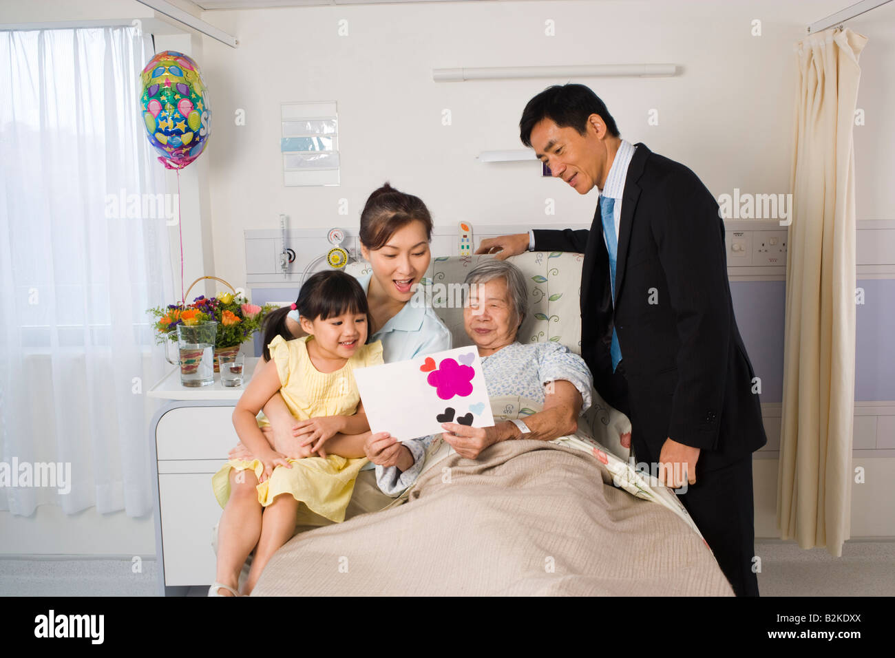 Female patient and her family looking at a Get Well card Stock Photo ...
