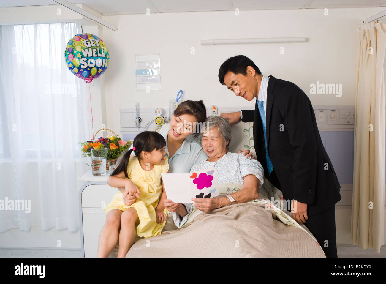 Female patient and her family looking at a Get Well card Stock Photo ...