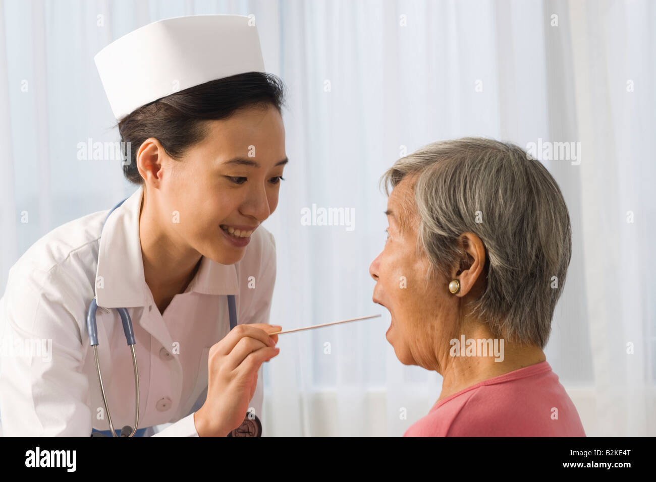 Female nurse examining a patient Stock Photo - Alamy