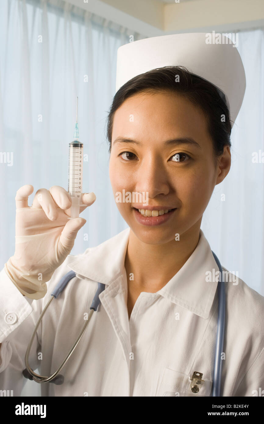 Portrait of a female nurse holding an injection and smiling Stock Photo ...