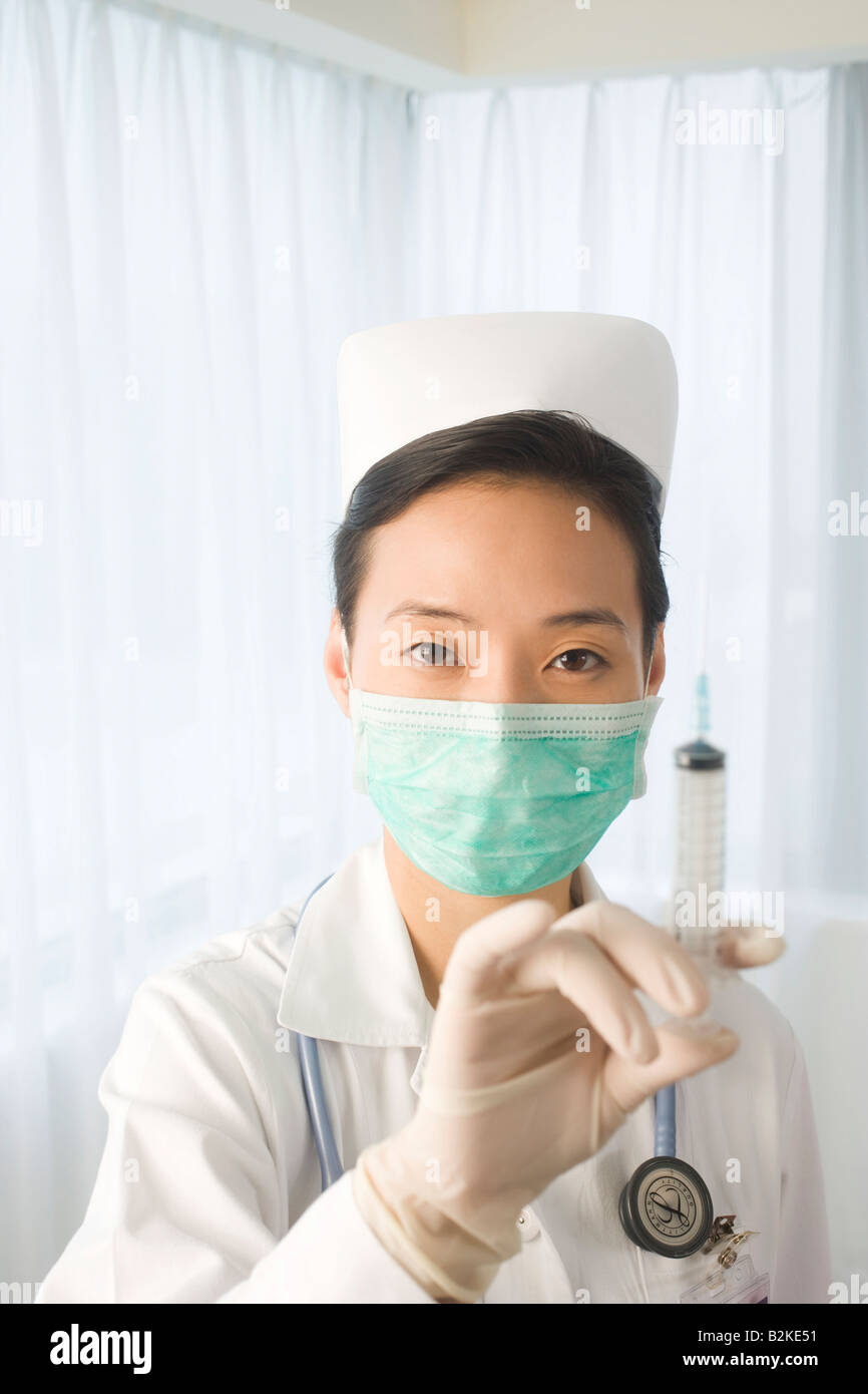 Portrait of a female nurse holding an injection Stock Photo - Alamy