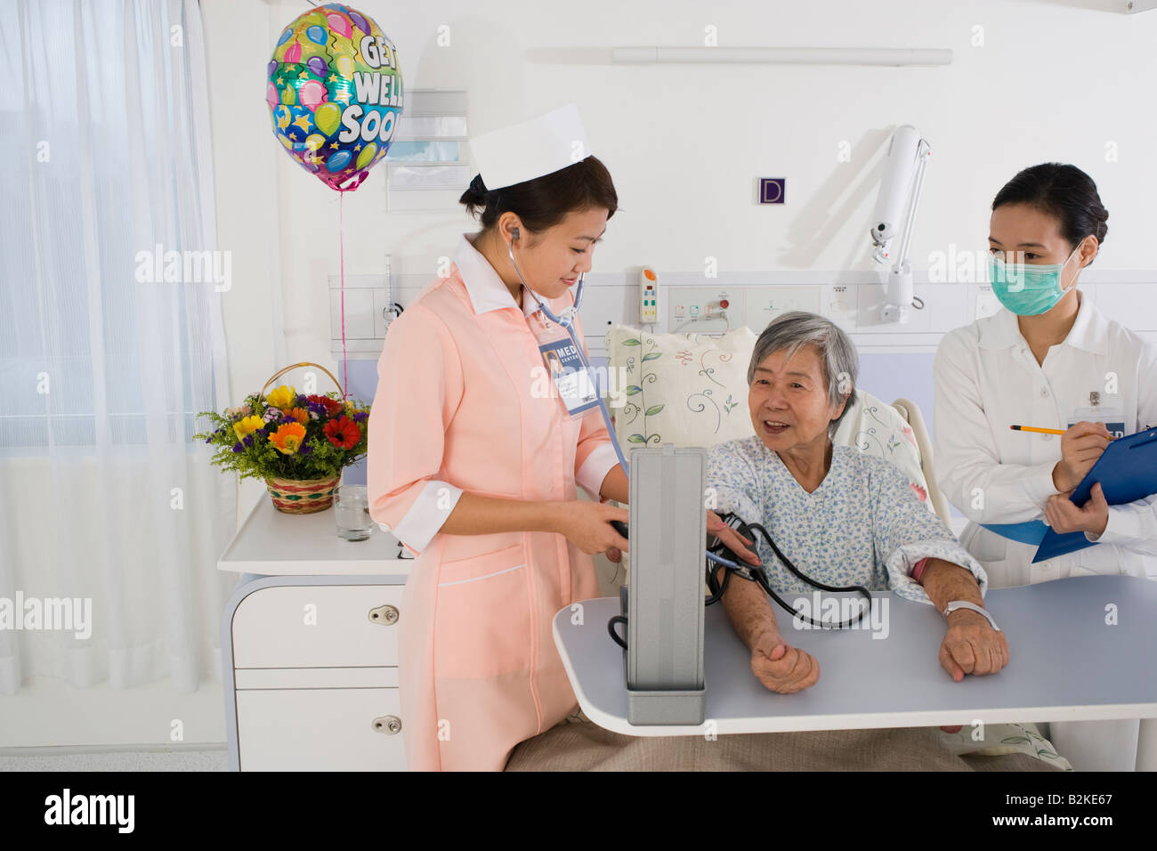 Female nurse checking a patient's blood pressure Stock Photo - Alamy