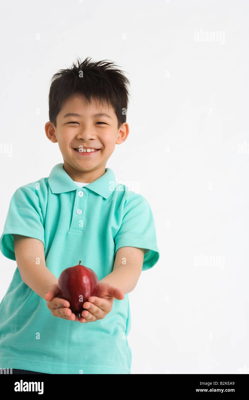 Portrait of a boy holding an apple and smiling Stock Photo - Alamy