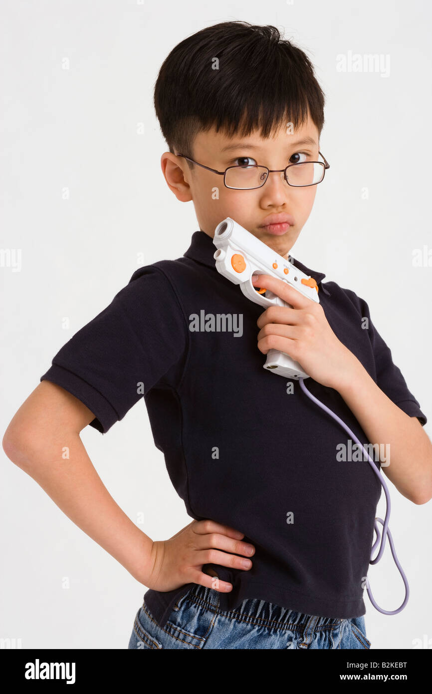 Portrait of a boy holding a video game gun Stock Photo - Alamy