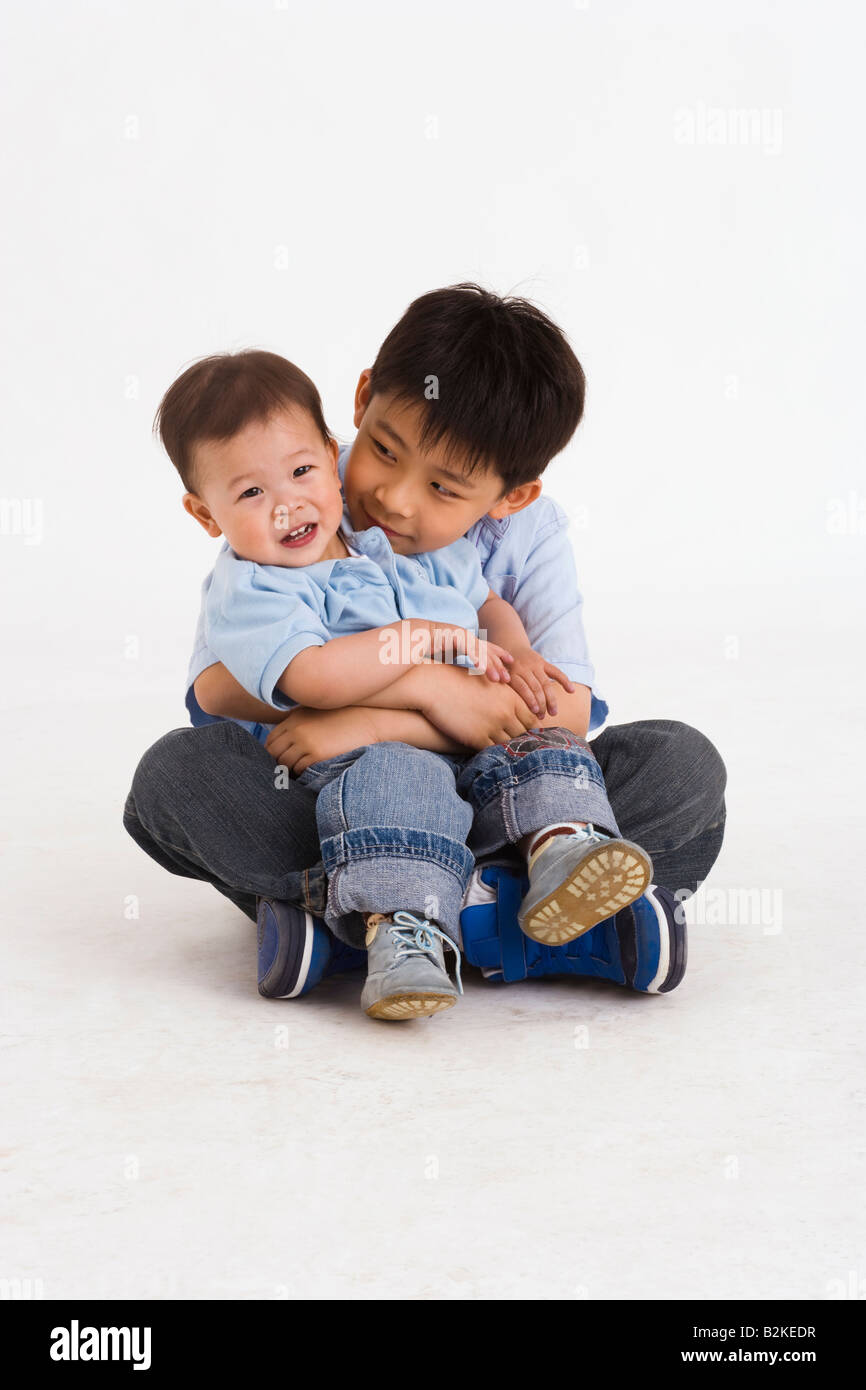 Boy sitting on lap of his brother Stock Photo - Alamy