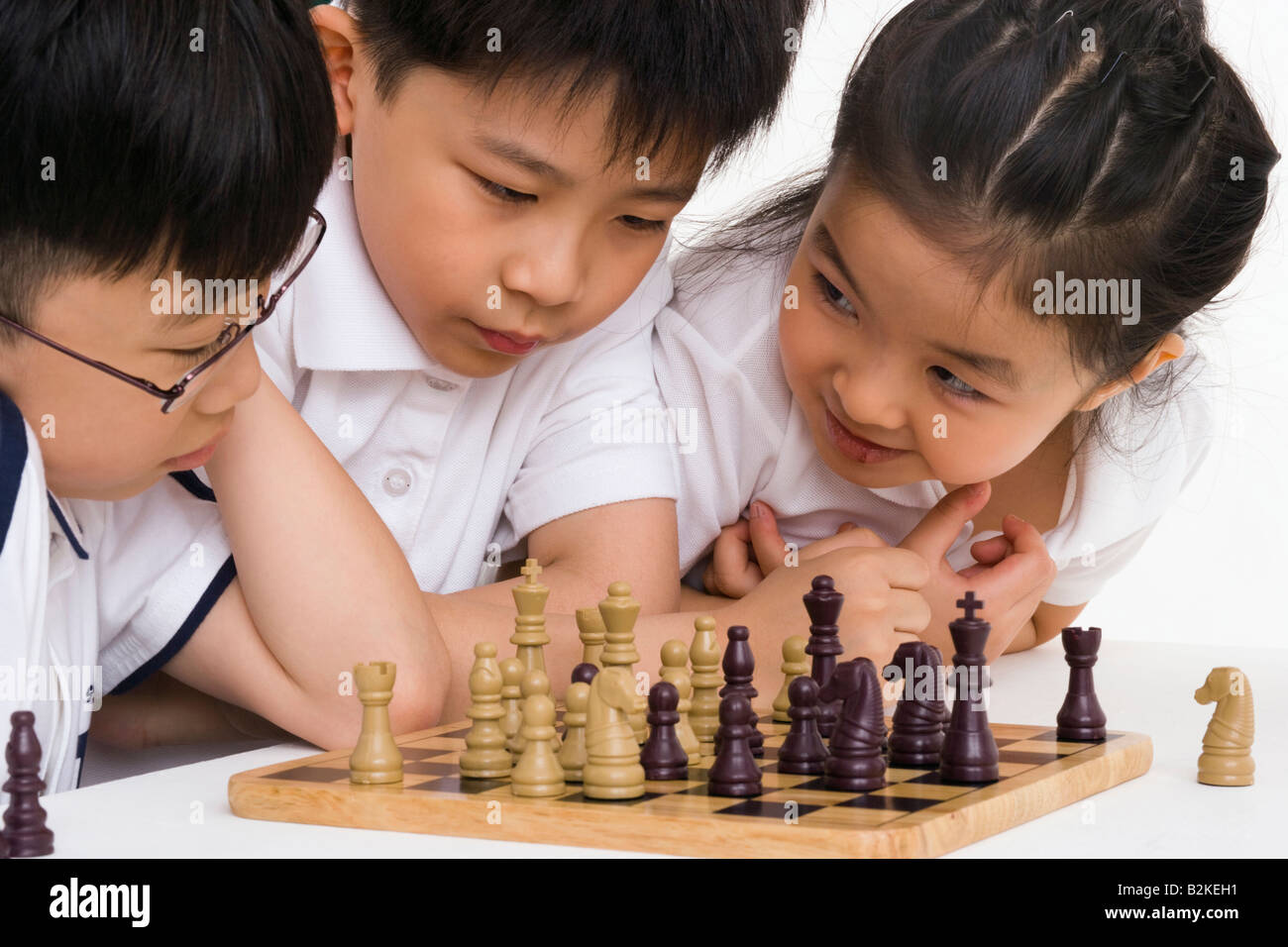 Three children playing chess Stock Photo - Alamy