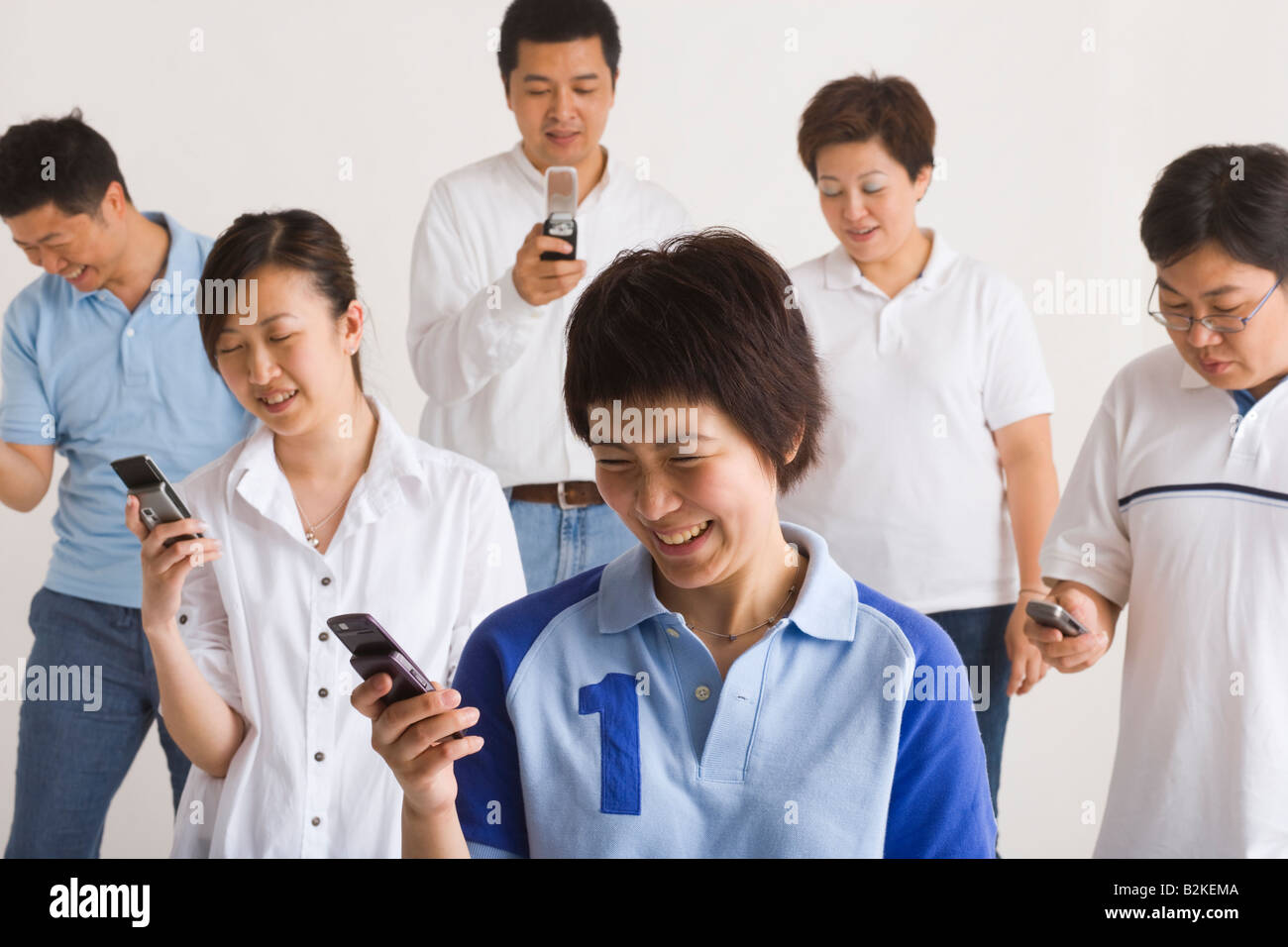 Group of mid adult people text messaging Stock Photo - Alamy
