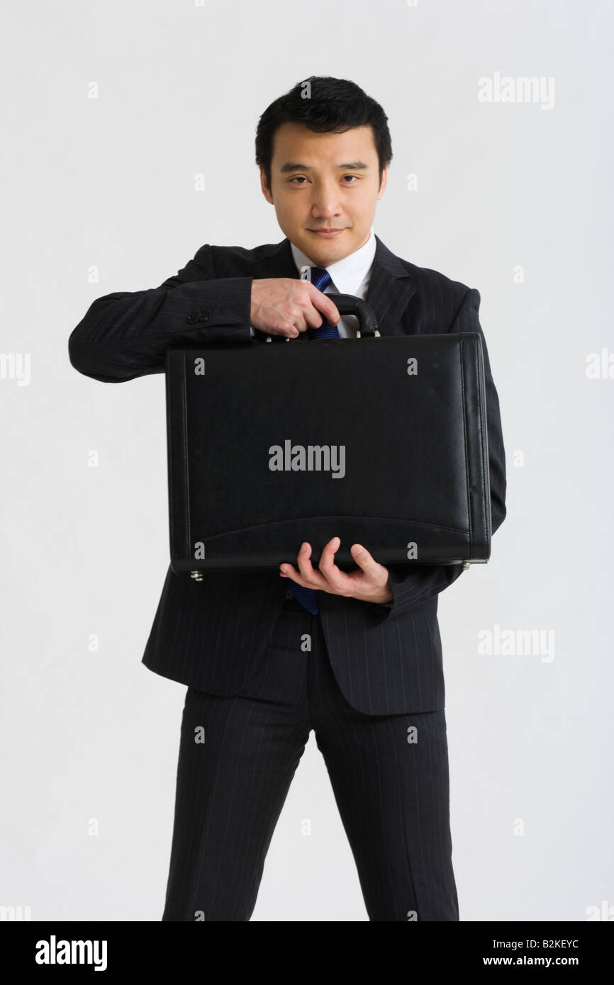 Portrait of a businessman holding a briefcase Stock Photo - Alamy