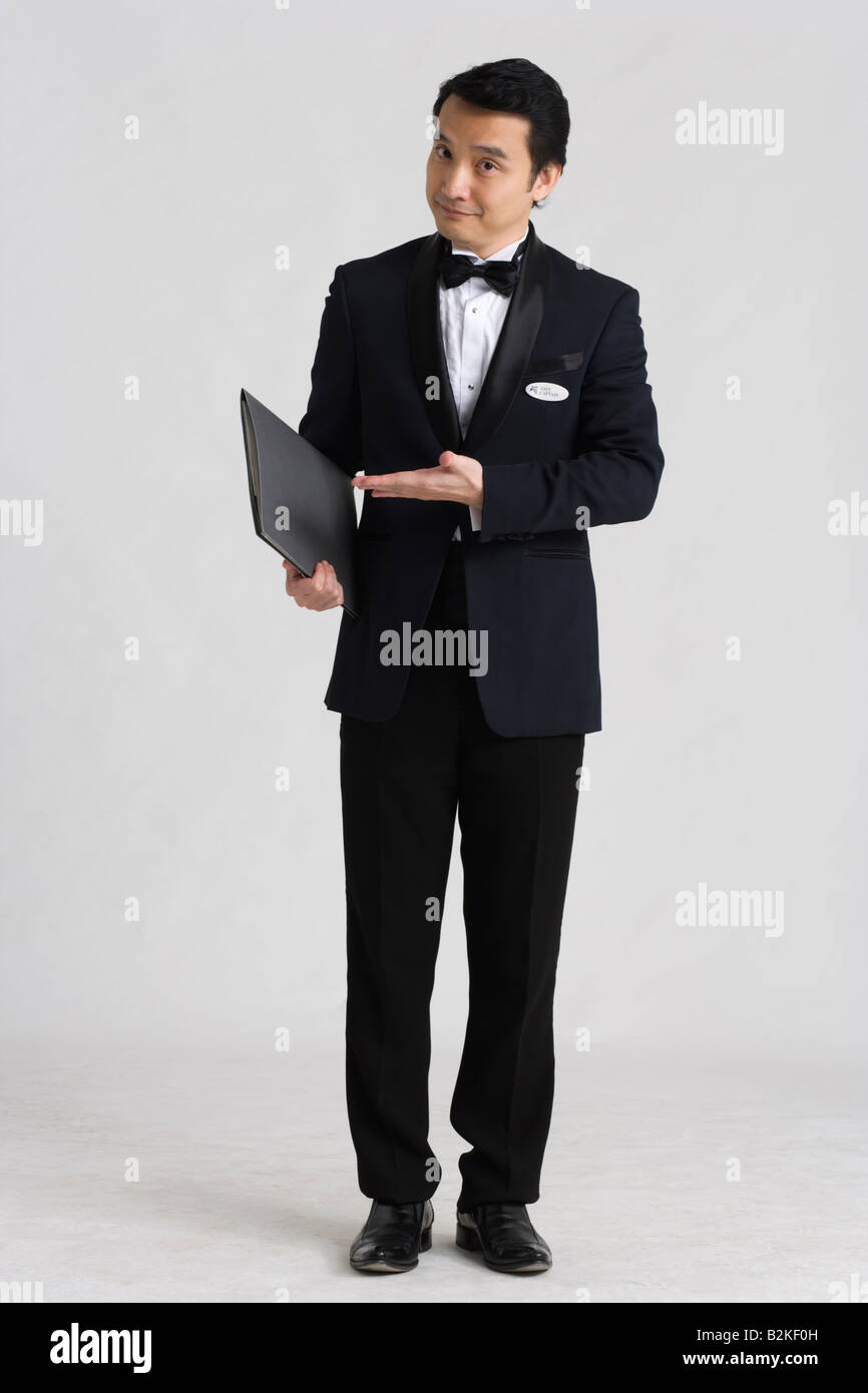 Portrait of a waiter holding a menu and standing Stock Photo - Alamy