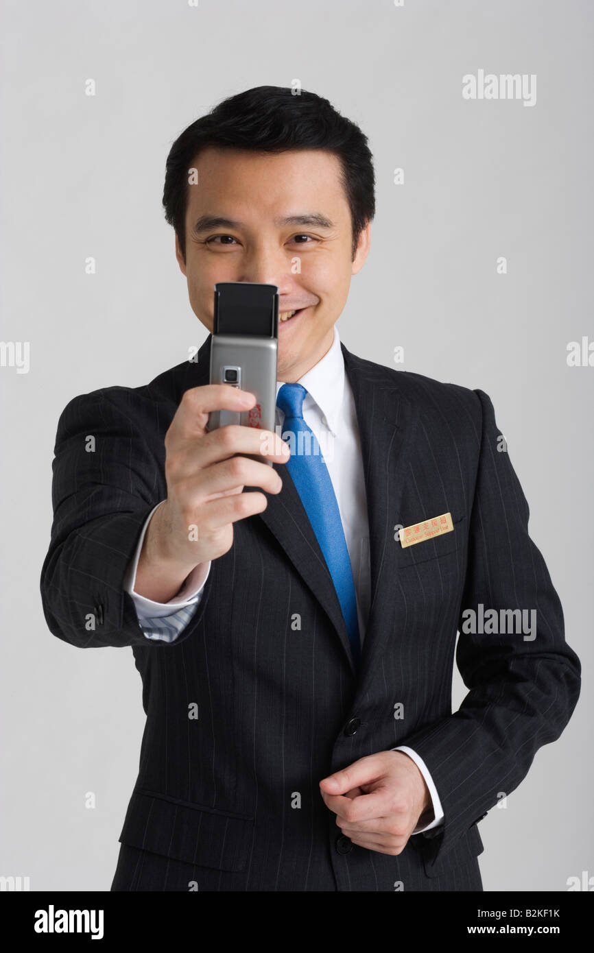 Portrait of a businessman text messaging and smiling Stock Photo - Alamy