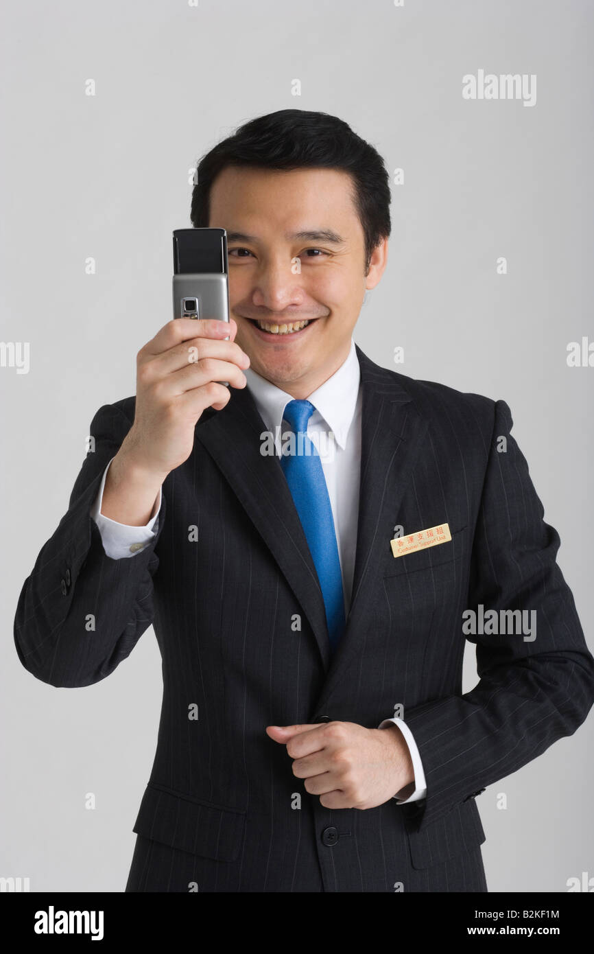 Portrait of a businessman text messaging and smiling Stock Photo - Alamy