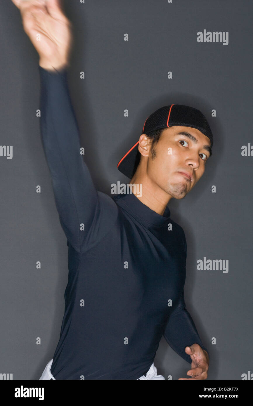 Portrait of a young man standing with his hand raised Stock Photo - Alamy