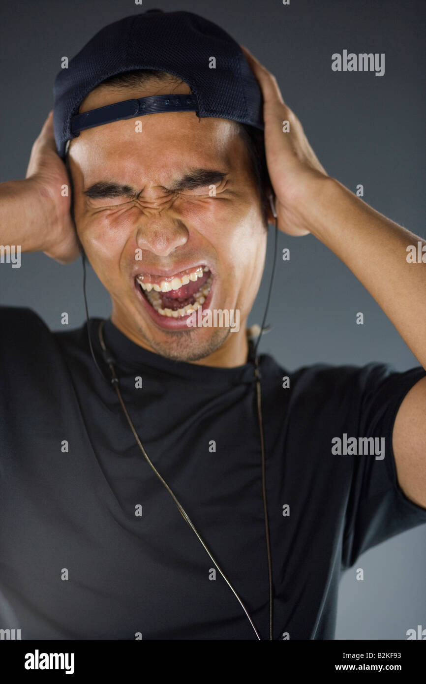 Close-up of a young man listening to music and shouting Stock Photo - Alamy