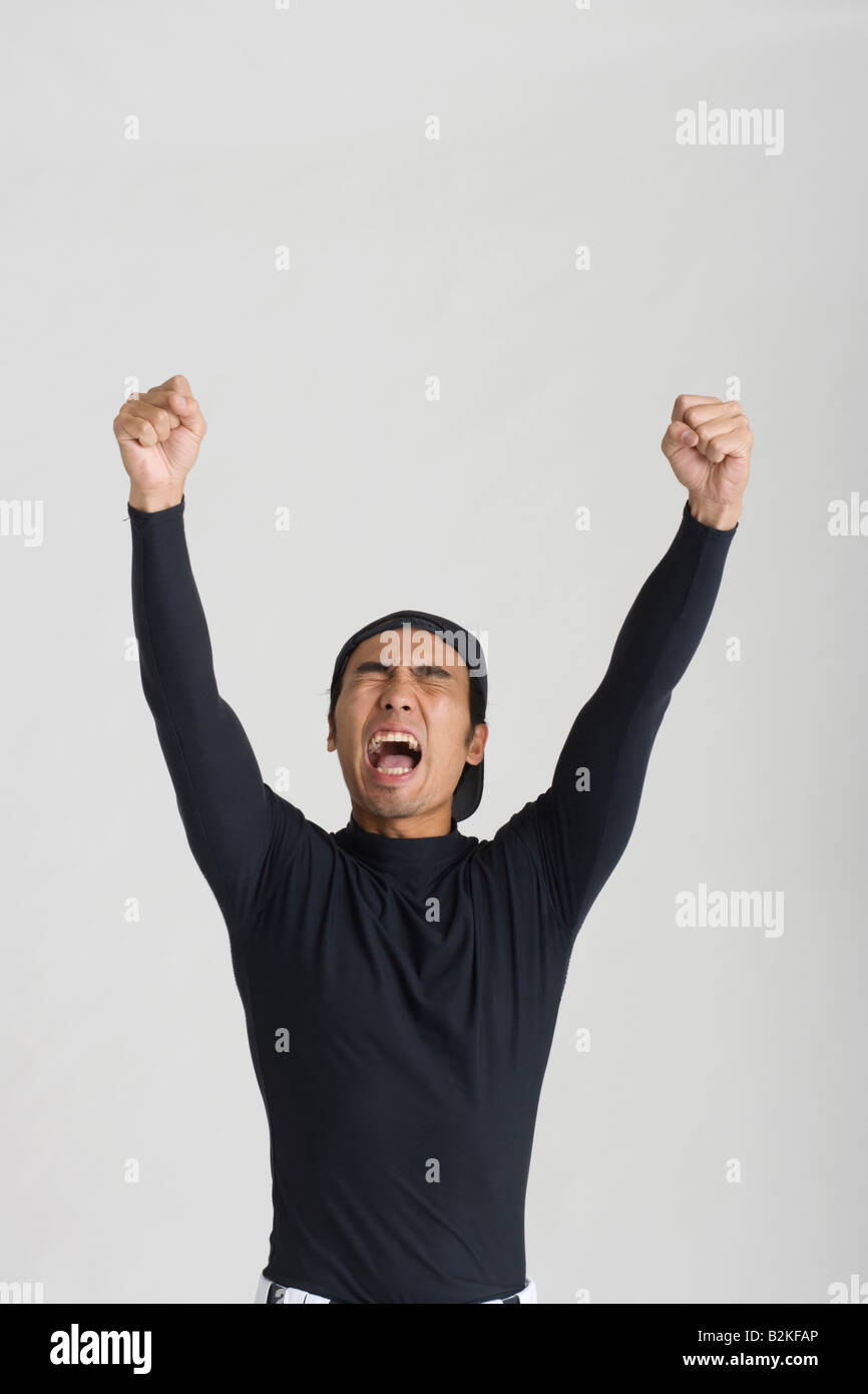 Young man standing with arms raised and shouting Stock Photo - Alamy