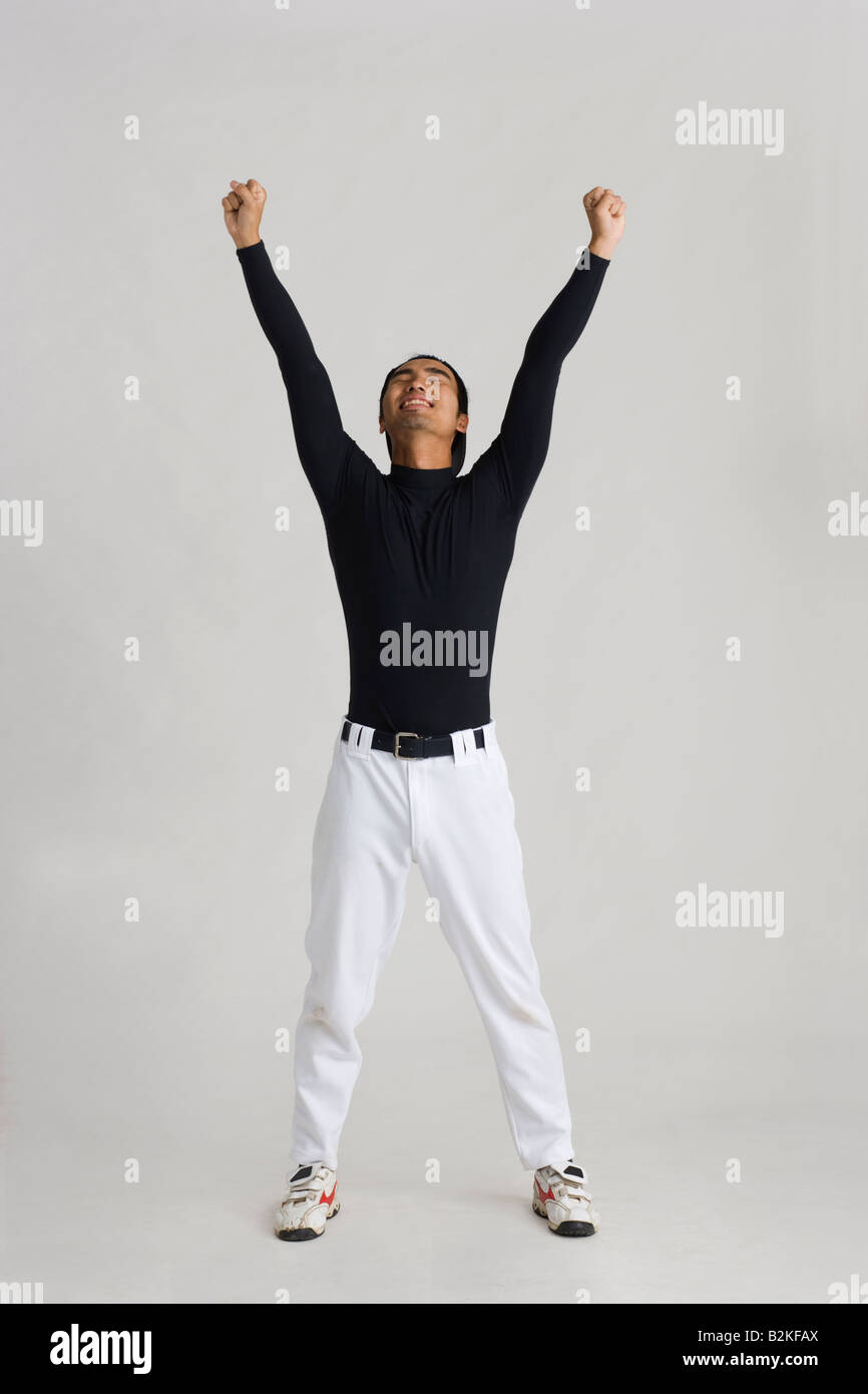Young man standing with arms raised and smiling Stock Photo - Alamy