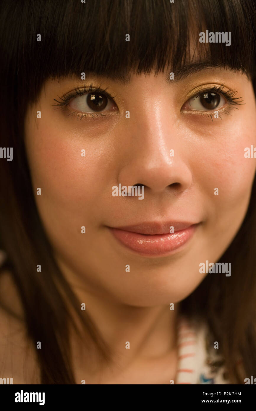 Close-up of a young woman smirking Stock Photo - Alamy