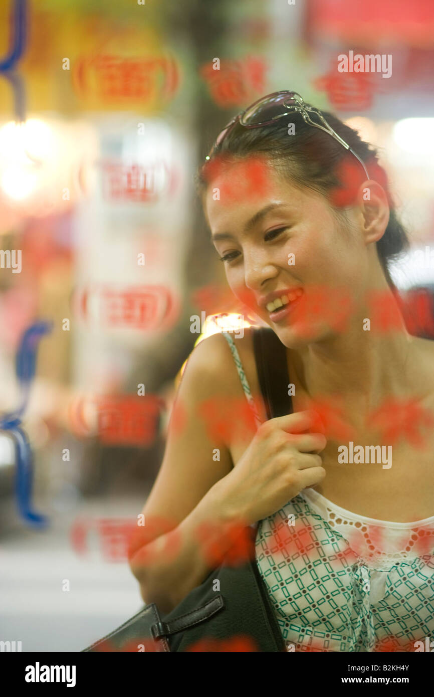 Young woman looking at a window display Stock Photo - Alamy