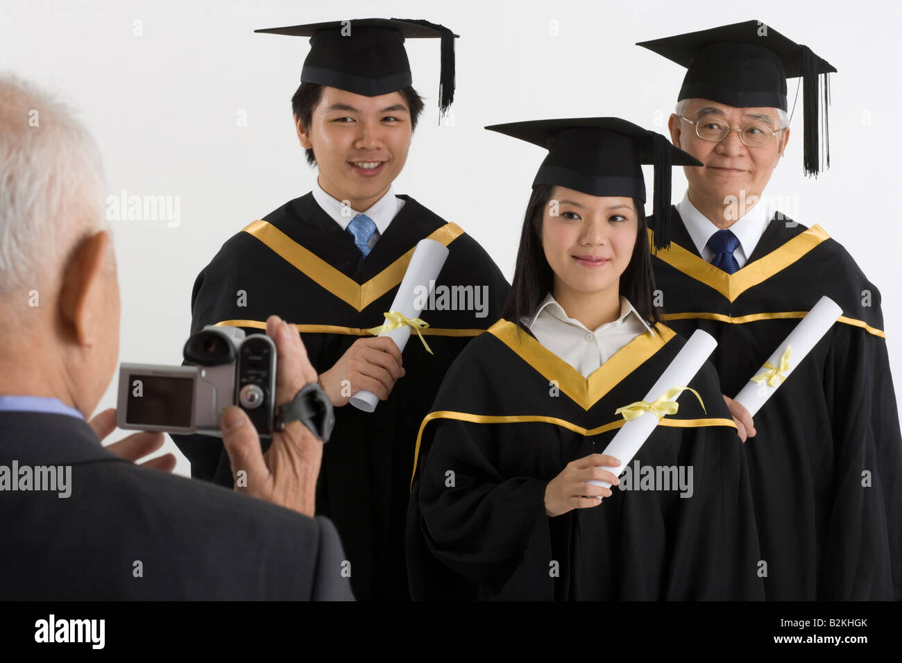 Rear view of a professor filming his students with a home video camera ...