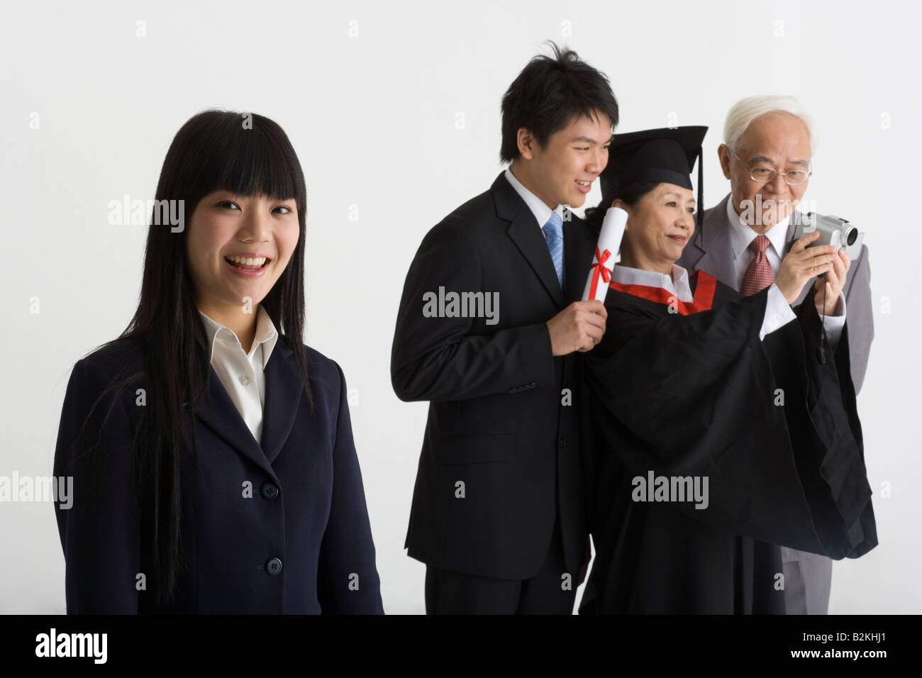 Young woman smiling with her family looking at a home video camera in ...