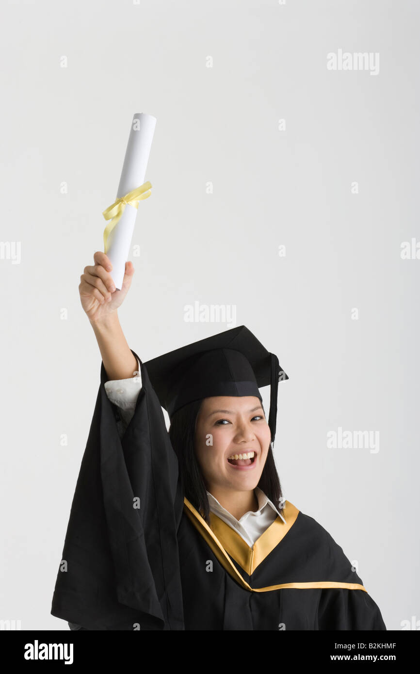 Portrait of a young female graduate holding a diploma with her hand ...